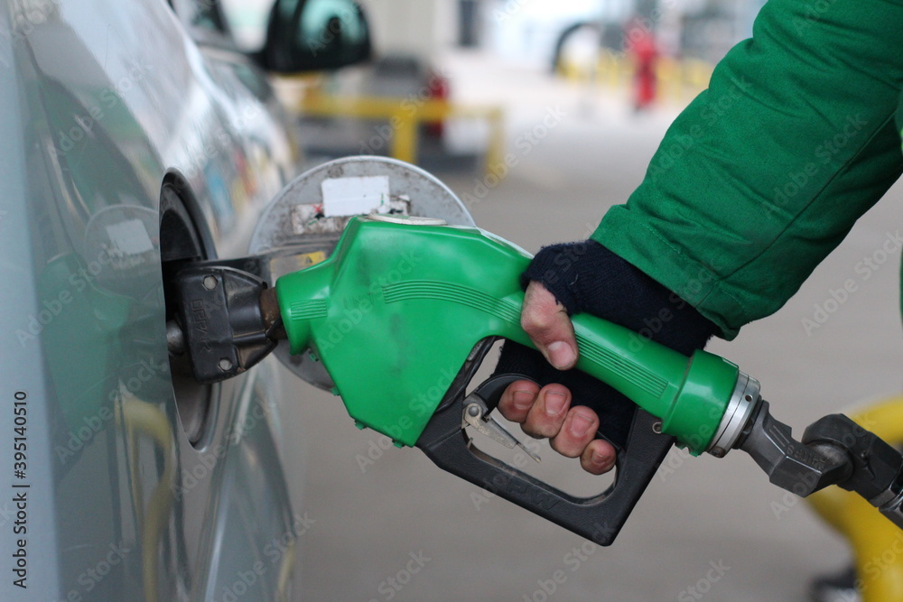 gas pump nozzles at gas station - Human hand filling fuel with pump at ...