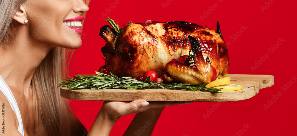 Closeup of smiling sexy blonde woman in holding tasty whole roasted ...