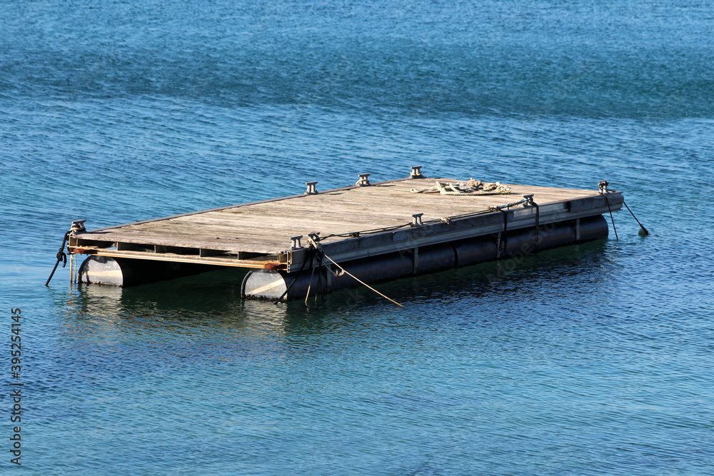 Elongated homemade makeshift old floating pier made from empty metal ...