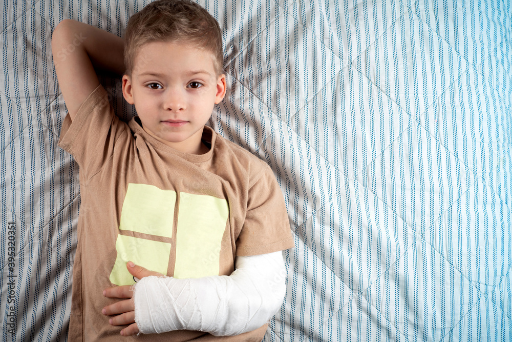 Little Boy Lies On The Bed With A Fractured Limb A Child s Arm Is little-boy-lies-on-the-bed-with-a-fractured-limb-a-child-s-arm-is