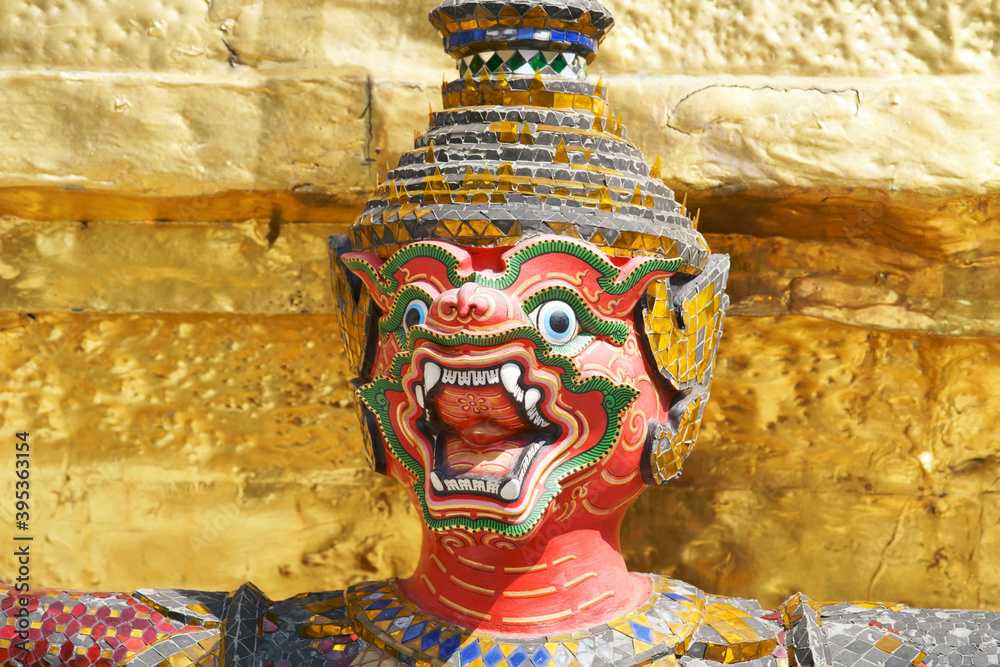 head of ramayana statue with golden pagoda background at wat phra kaew ...