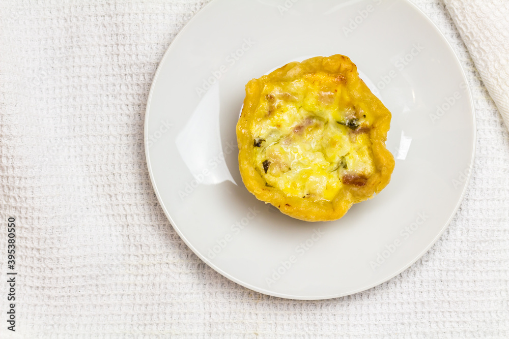 Foto de Mini quiche with bacon, egg, cheese and parsley on white ...