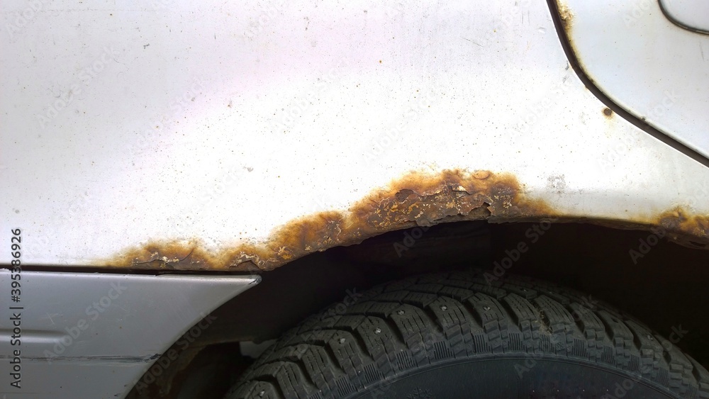 Sheet metal corrosion over wheel of old white car. Rusty messy surface ...