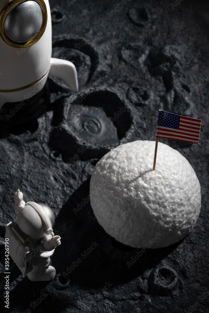 astronaut cheering up and facing the American flag on a planet with ...