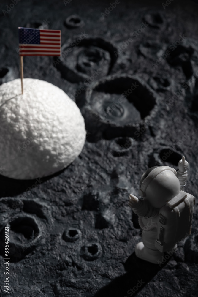 astronaut cheering up and facing the American flag on a planet with ...