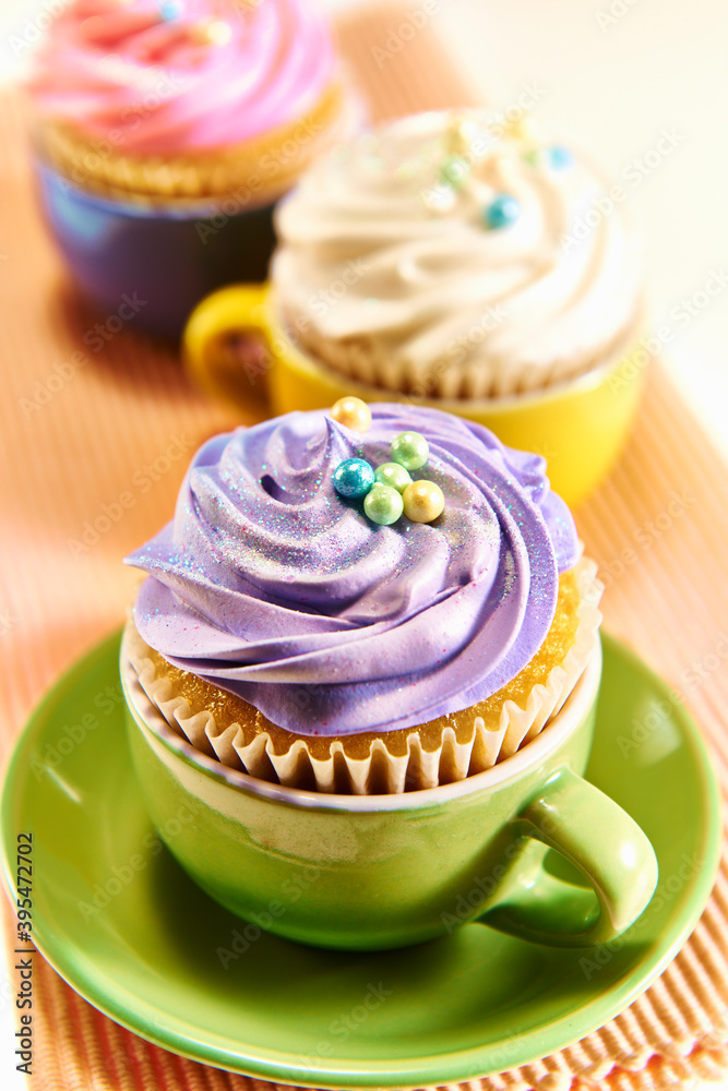Cupcakes decorated with different coloured buttercream served in ...