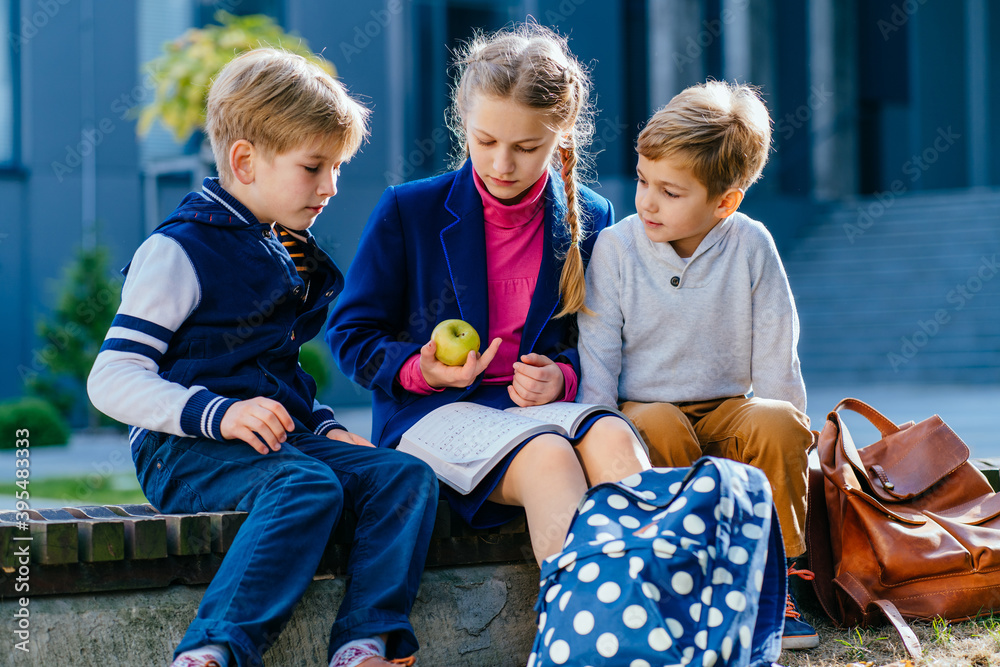 Group of three children reading from notebook all together. School kids ...