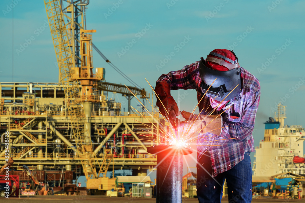 Welders is welding using MIG/MAG Welding gun on rig oil plant yard ...