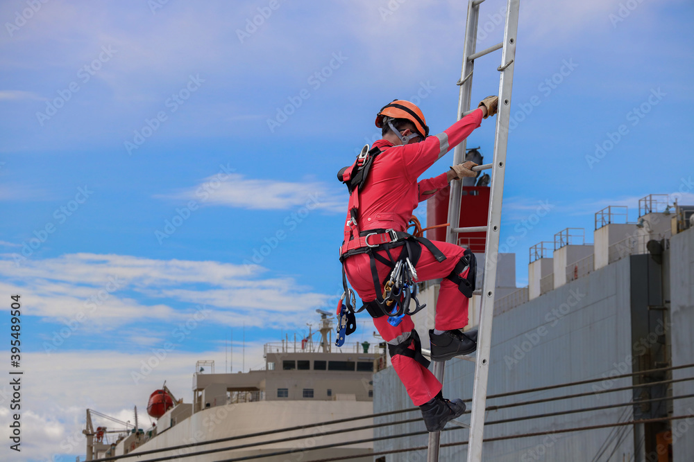 Safety concept Worker wearing seat belts safety harness go up the ...
