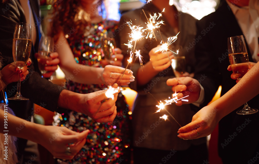 Sparkling sparklers in the hand. Group of happy people holding ...