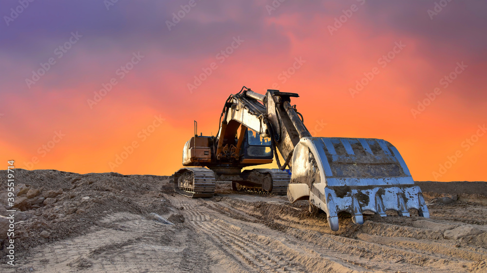 Excavator working on earthmoving at open pit mining on amazing sunset ...