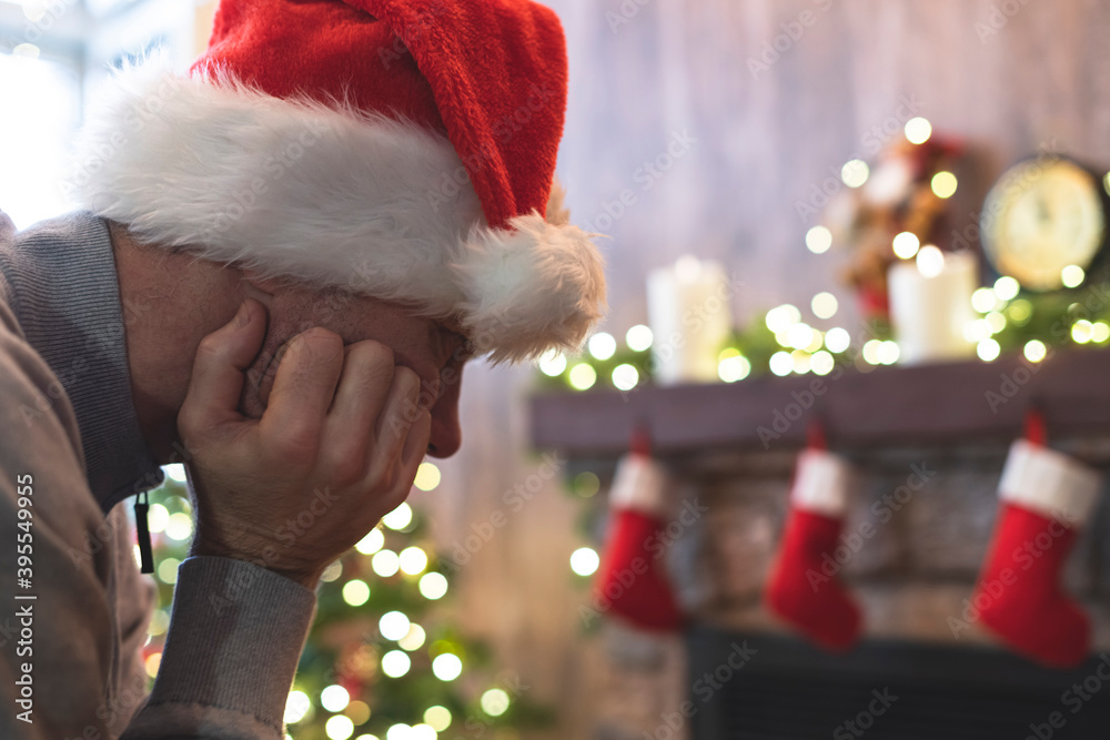 Sad man in Santa Claus hat in a depression feeling negative emotions ...