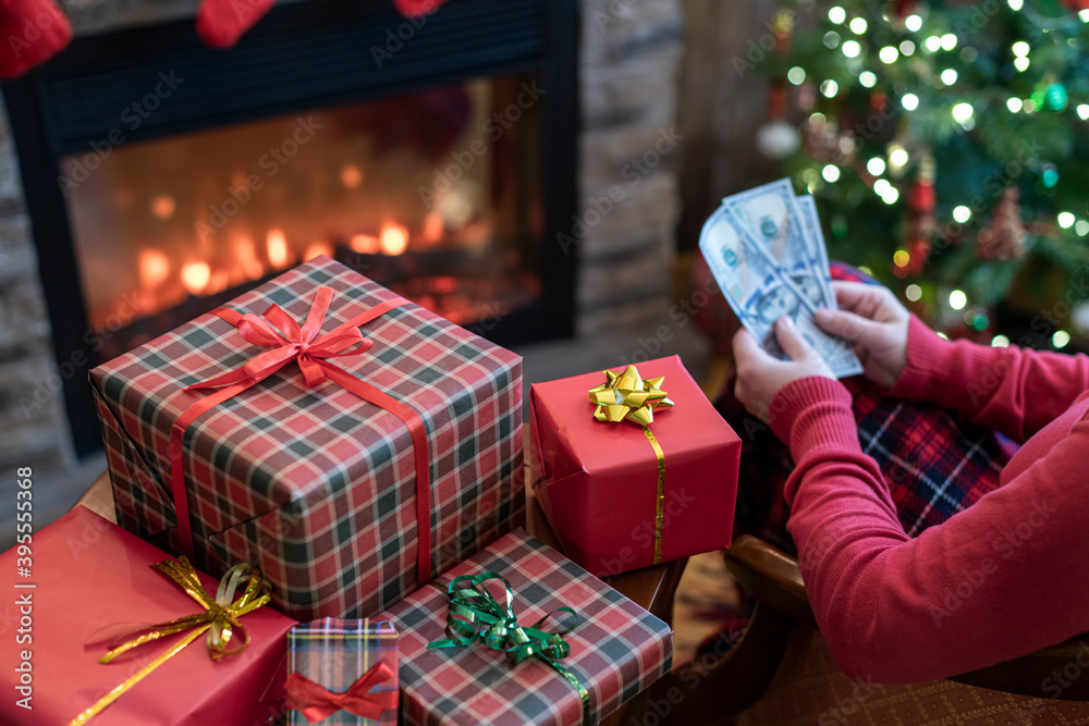 Woman counting american dollars planning sitting near christmas tree ...