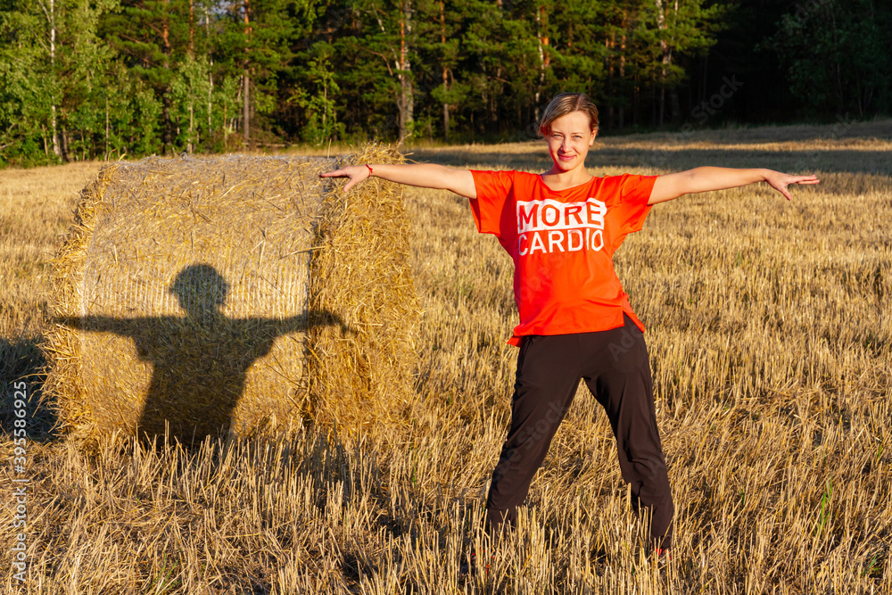 young pretty girl in sports uniform doing gymnastics outdoors in the ...
