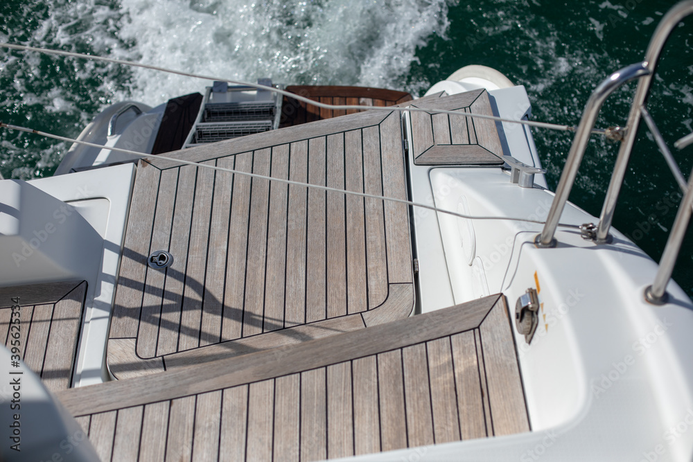View of the blue sea water from the side of a sailboat with rigging and ...
