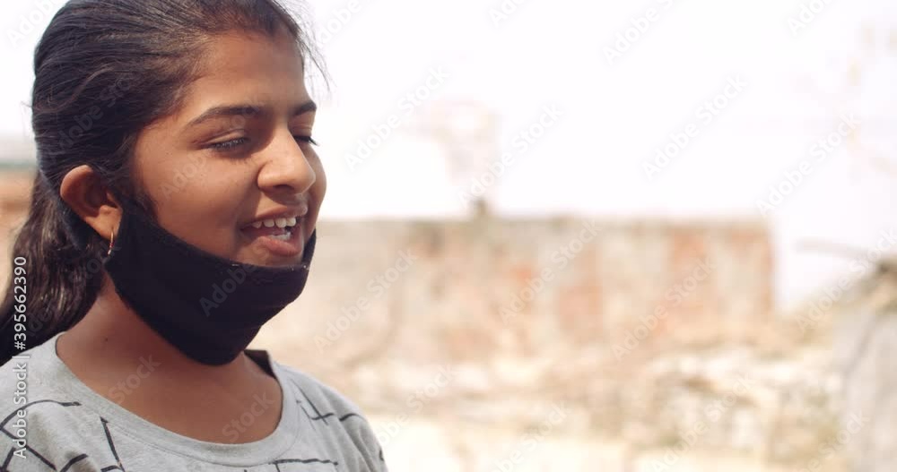 Handheld Close-up CU portrait of a young Indian woman in rural streets ...