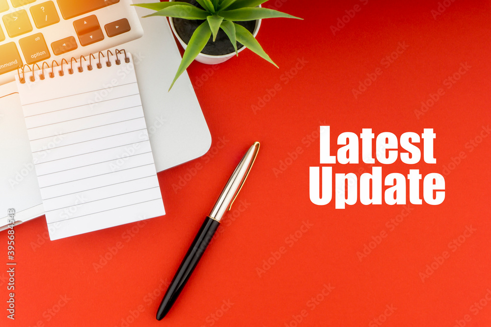 LATEST UPDATE text with notepad, laptop, fountain pen and decorative ...