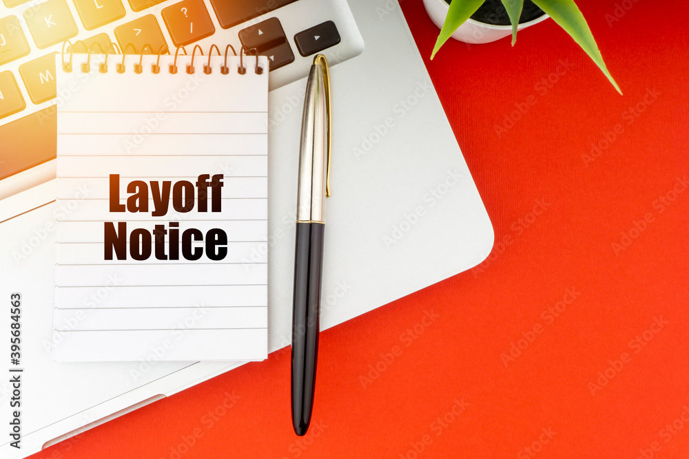LAYOFF NOTICE text with notepad, laptop, fountain pen and decorative ...