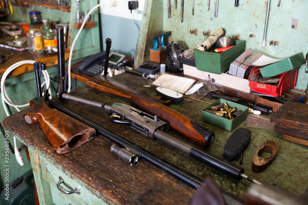 Workplace of gunsmith in professional weapons workshop with tools and ...