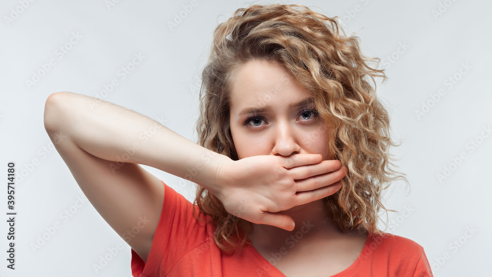 Image of blonde girl shutting mouth palm of the hand, promises to keep ...