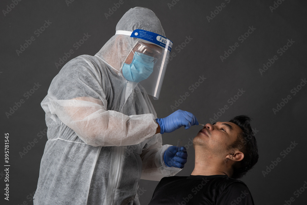 male with Personal protective equipment testing a swab for pandemic ...