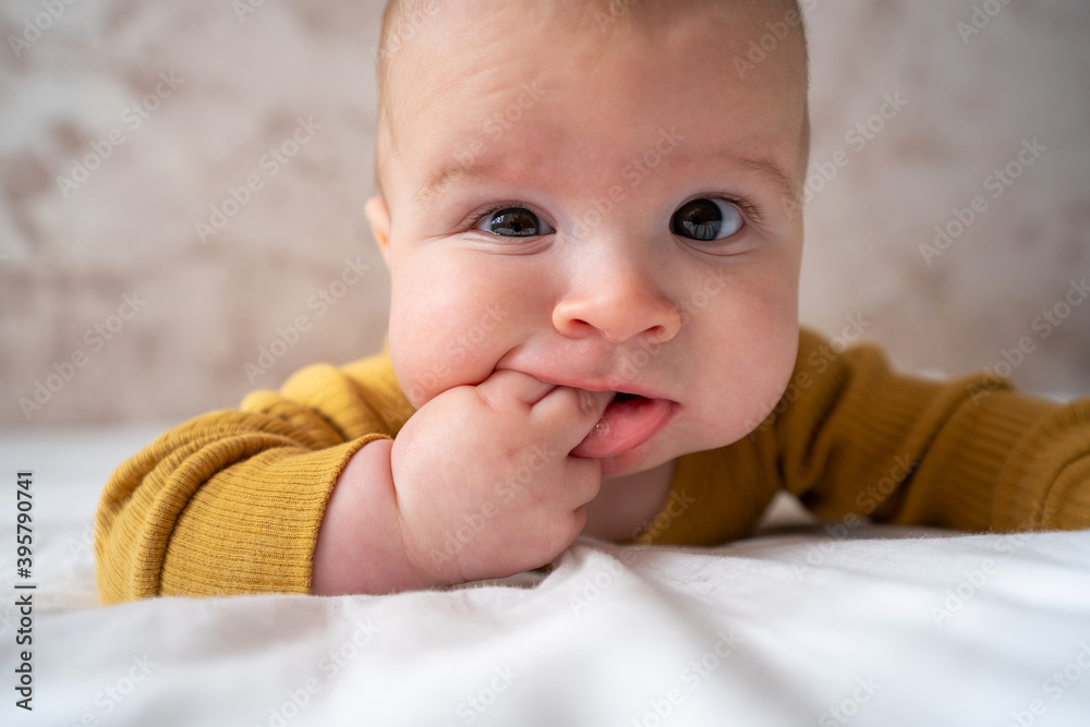 Small cute funny baby infant teething with face expression hands and ...