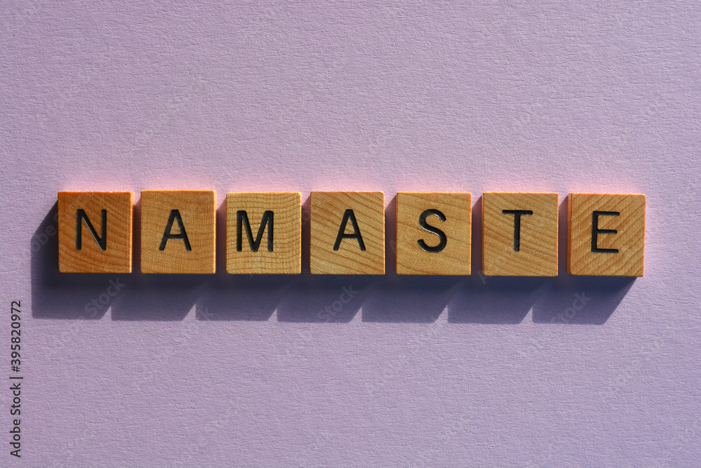 Namaste, word in wooden alphabet letters isolated on purple background ...