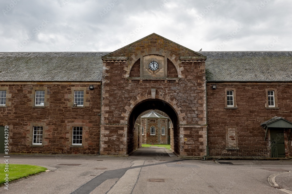 Red brick barracks with a arch gate and clock in historical Fort George ...