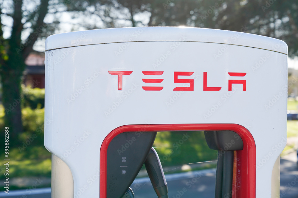 Tesla logo sign on supercharger white and red station charging of ...