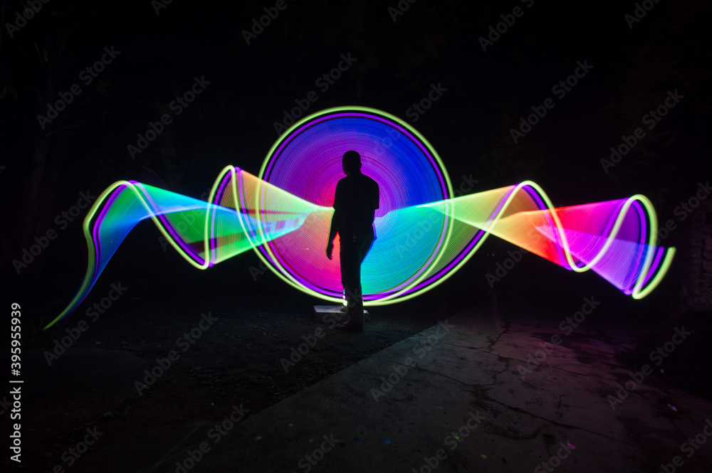 One person standing alone against beautiful Colourful circle light ...