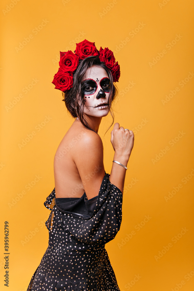 Slender dark-haired girl with beautiful posture posing in dress, baring ...