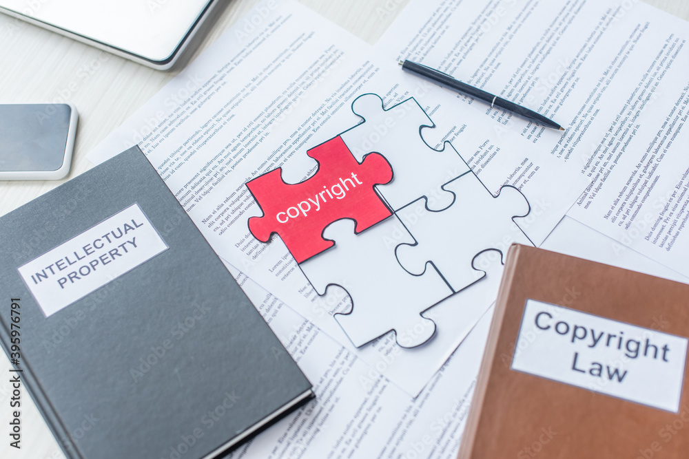 Jigsaw puzzles with copyright lettering on workplace with paperwork and ...