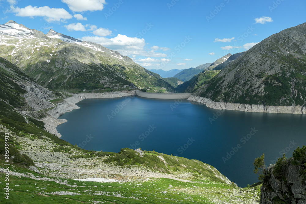 Dam in Austrian Alps. The artificial lake stretches over a vast ...