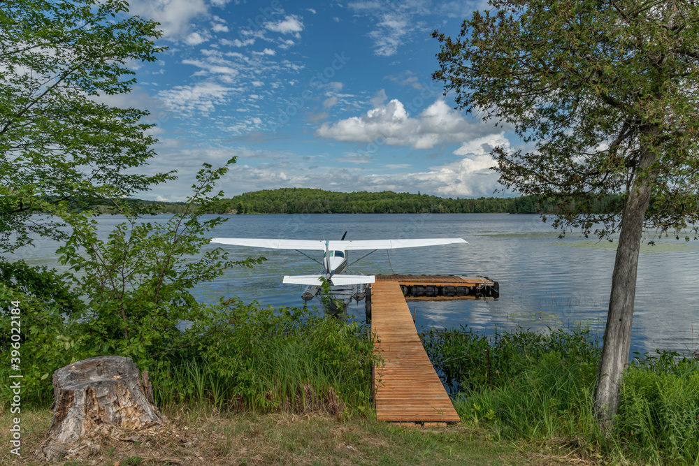 Float plane tied to a dock on a lake on a beautiful summer day Stock ...