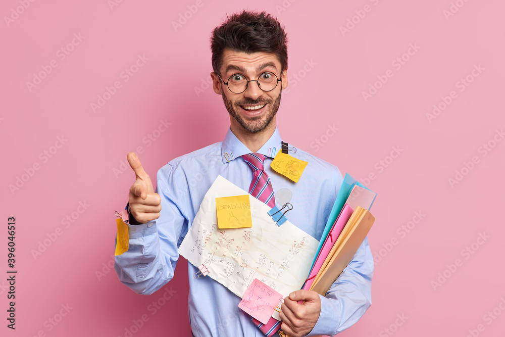 Happy positive male employee holds folders and paper documents ...