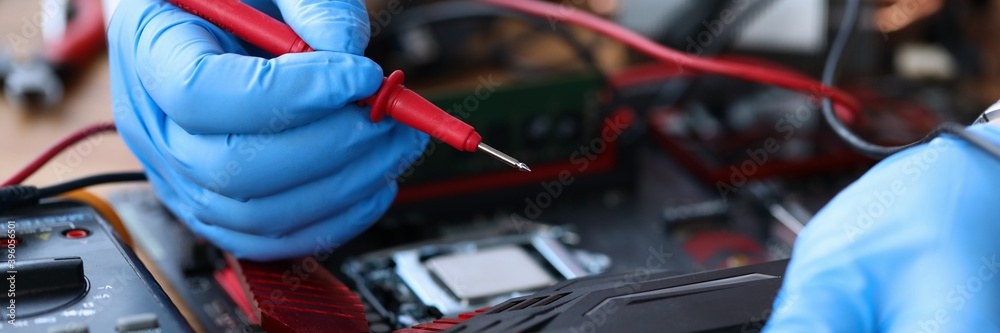 Gloved hands, on table repair an electronic device. Diagnosis device ...