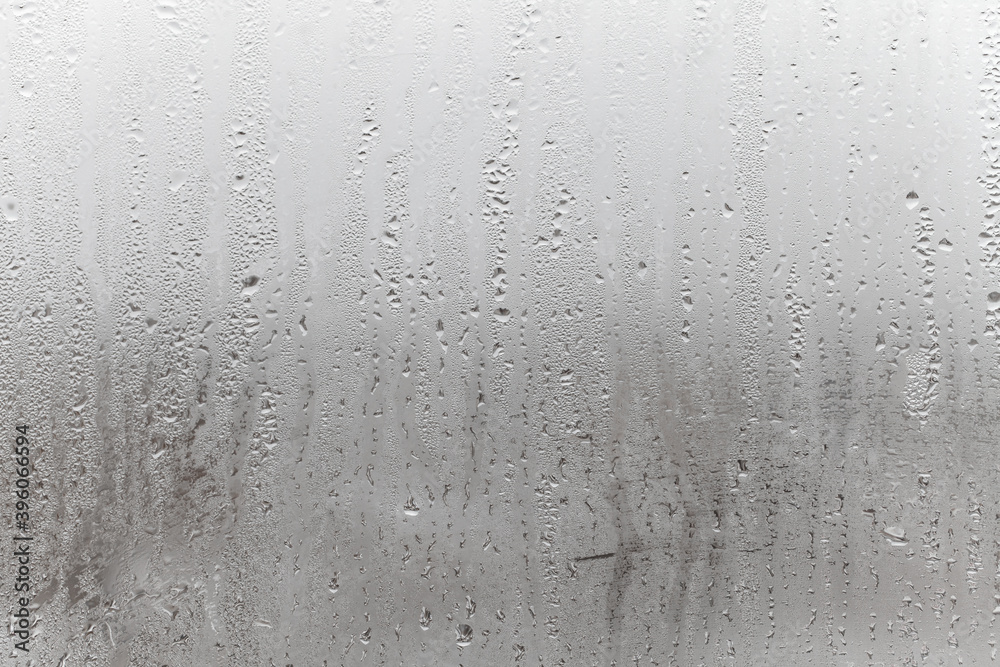 Natural drops of water flow down the glass, high humidity in the room ...
