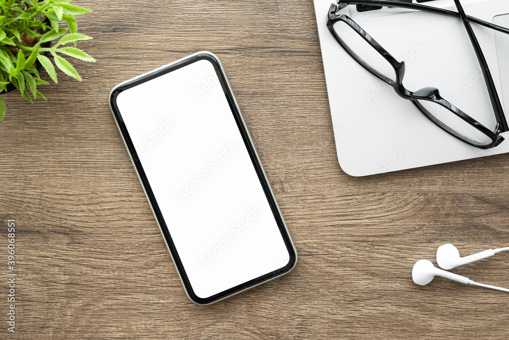 Smartphone with white blank mock up screen is on top of wood office ...