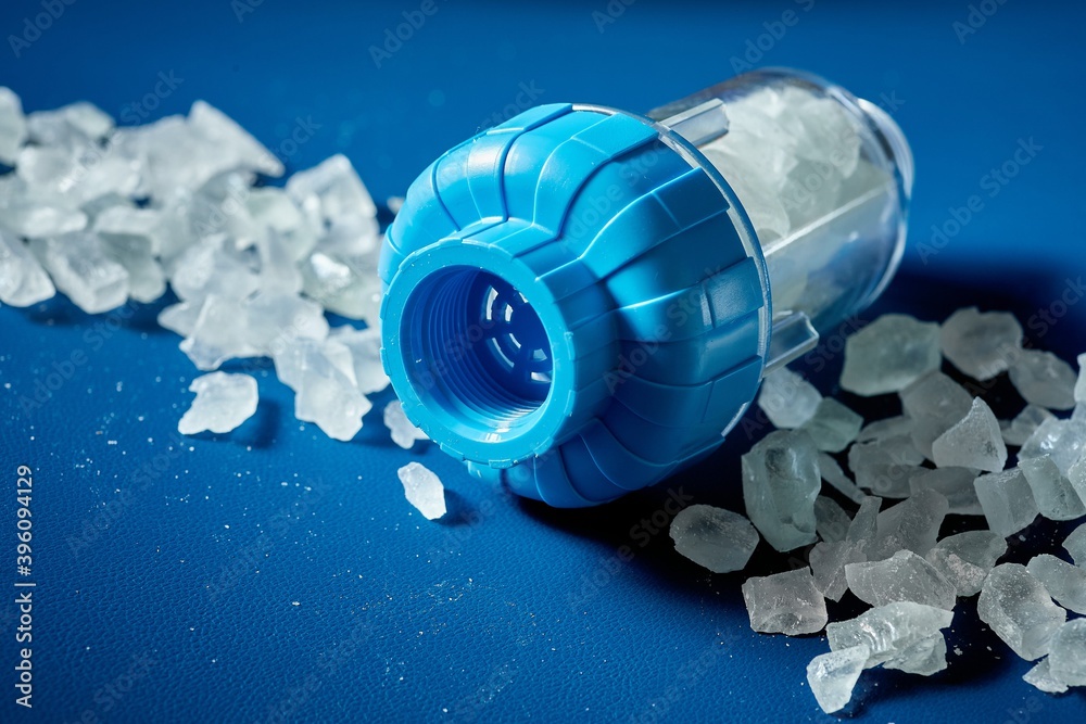 water filter with a crumb of salt crystals on a blue background Stock ...