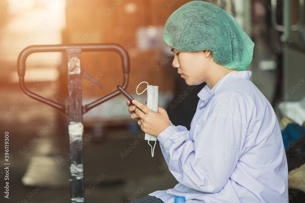 Asian Burmese young woman labor worker sit and relax, playing cell ...