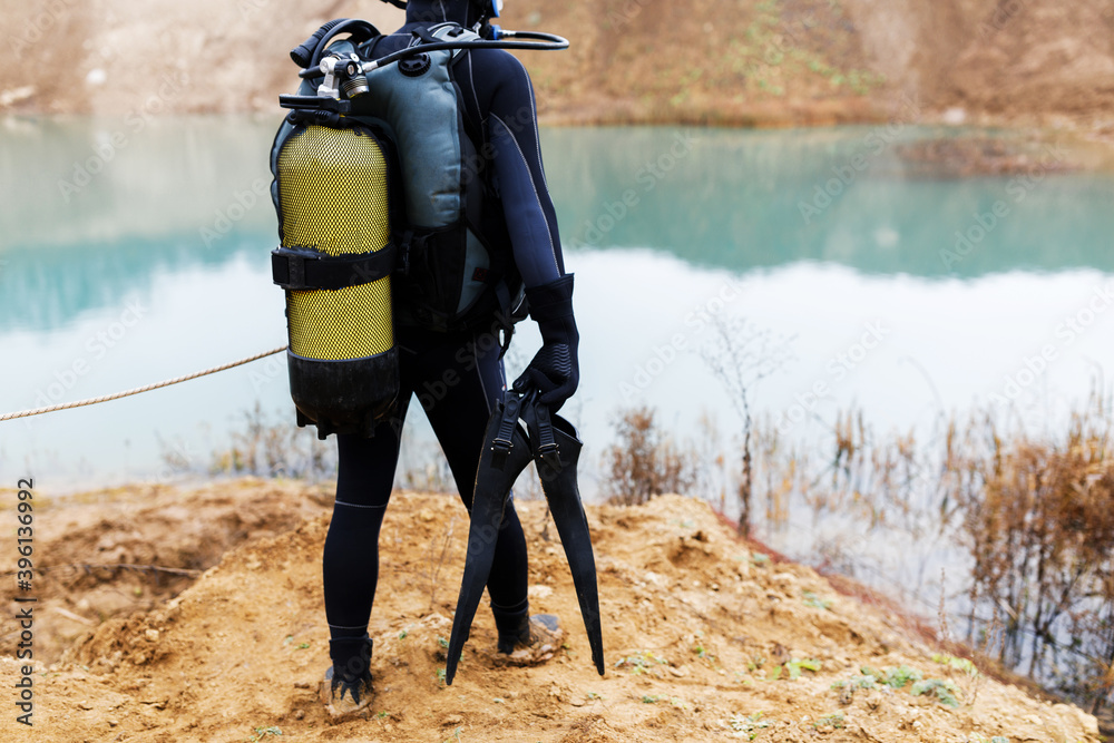 A lifeguard in a wetsuit is preparing to dive into the pond. Search at ...