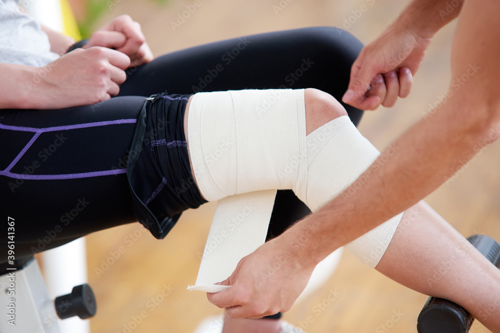 Applying a compression wrap for a sprained muscle. Close up ...