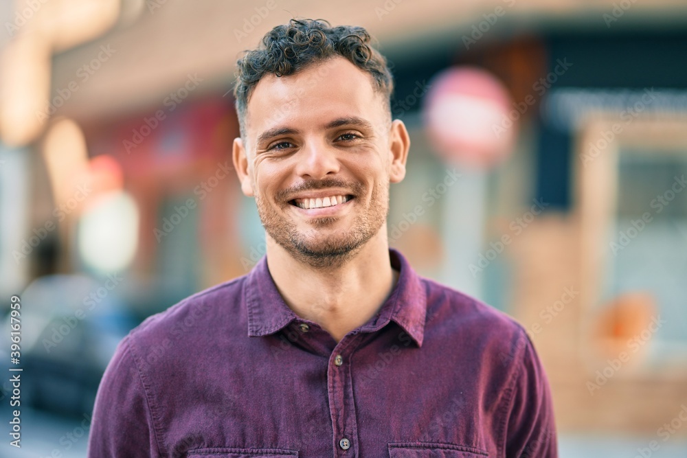 Young hispanic man smiling happy standing at the city. Stock Photo ...