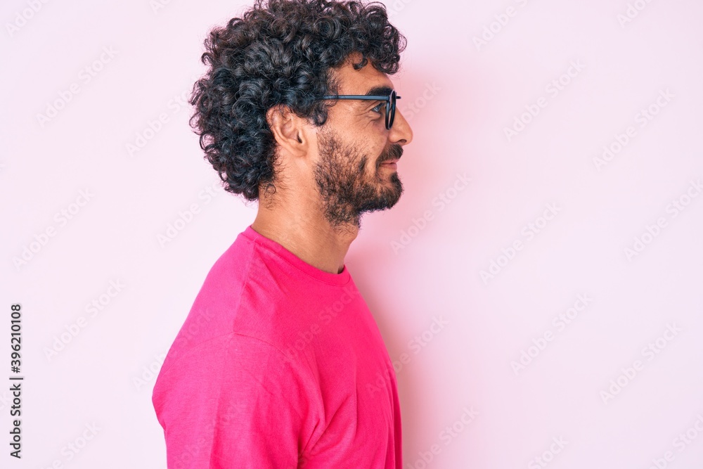 Handsome young man with curly hair and bear wearing casual clothes and ...