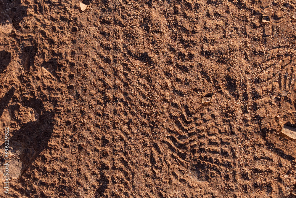 Dirt texture with on a trail outdoors with footprints and tire tracks ...