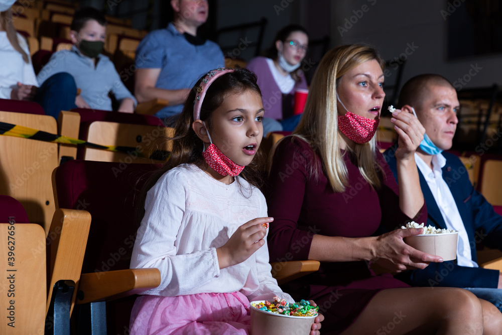 Portrait of cute preteen girl visiting cinema with parents during ...