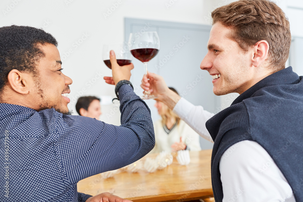 Two men toast with glass of wine at party at home Stock Photo | Adobe Stock