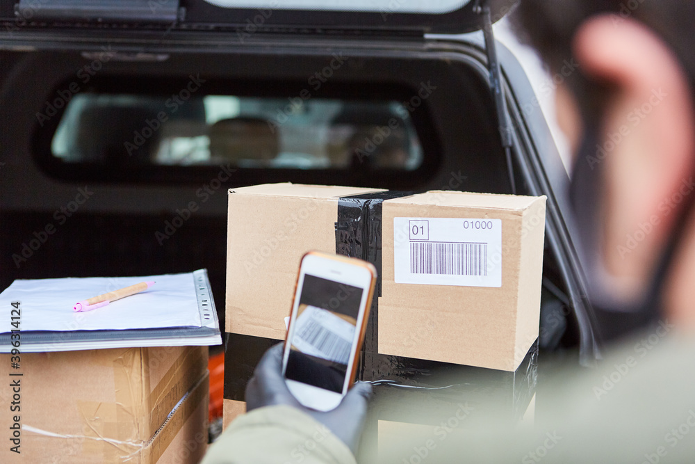 Paketbote scannt Barcode mit Smartphone von Paket Stock Photo | Adobe Stock