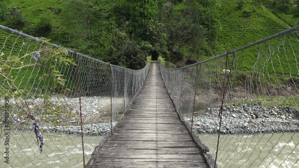 Vidéo Stock Wooden Simple Suspension Bridge Over River in Valley.A ...