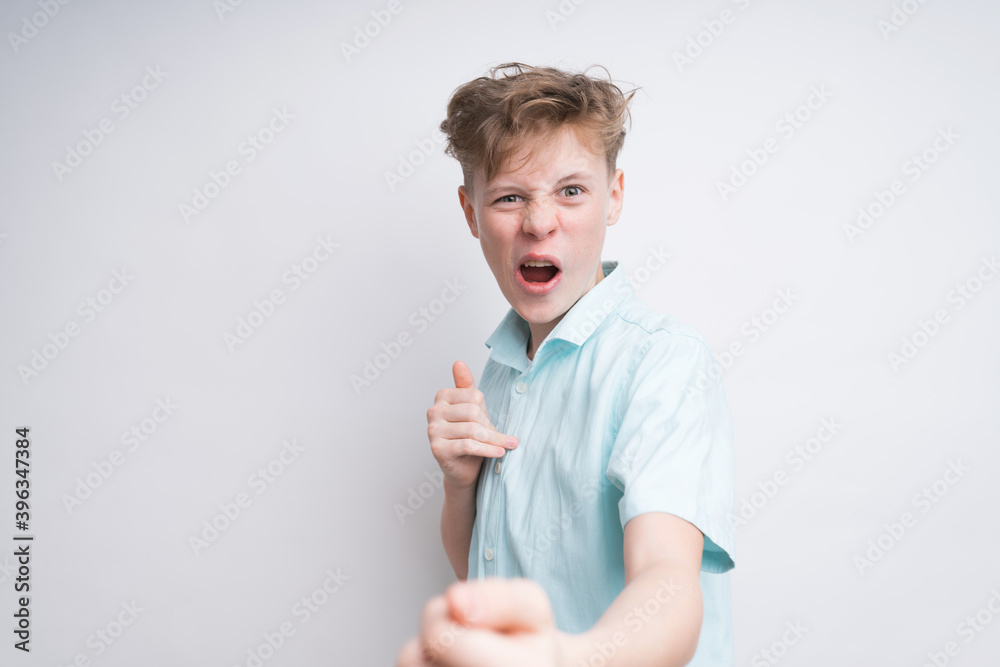 Funny extraverted Caucasian boy in a blue polo shirt on a white ...